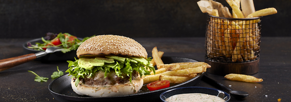 Klassisk burger med ost toppet med avokado